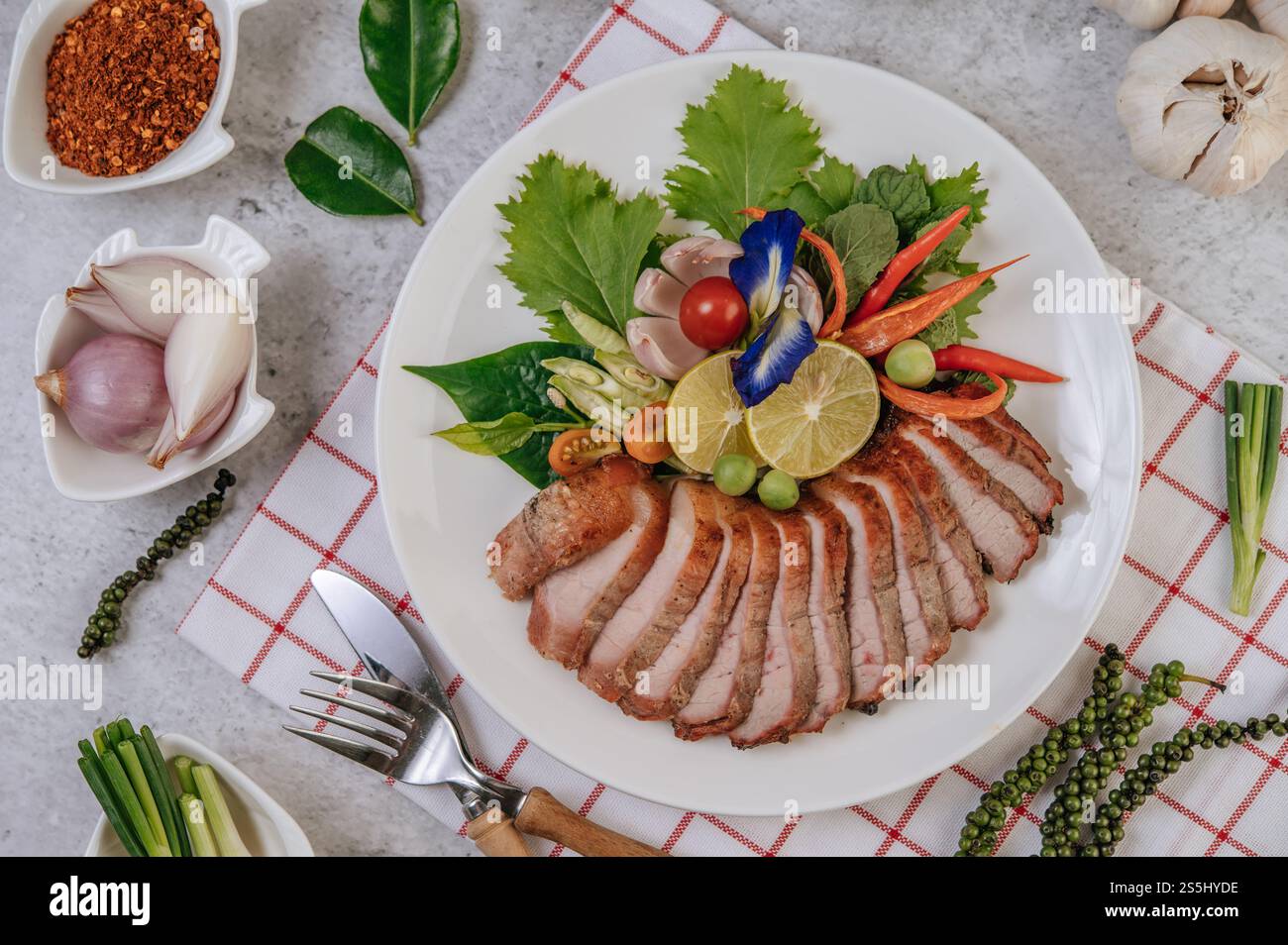 Sliced fried pork with lemon, onion, red onion, tomato, long bean ...