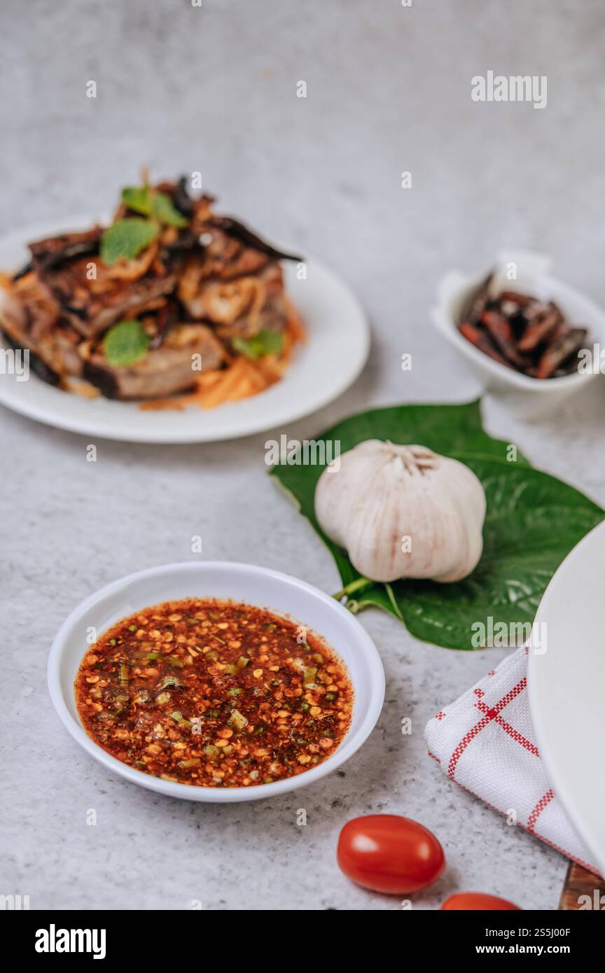 Thai Spicy Sauce, Larb Pork, Tomato and Garlic Put on a cement floor ...