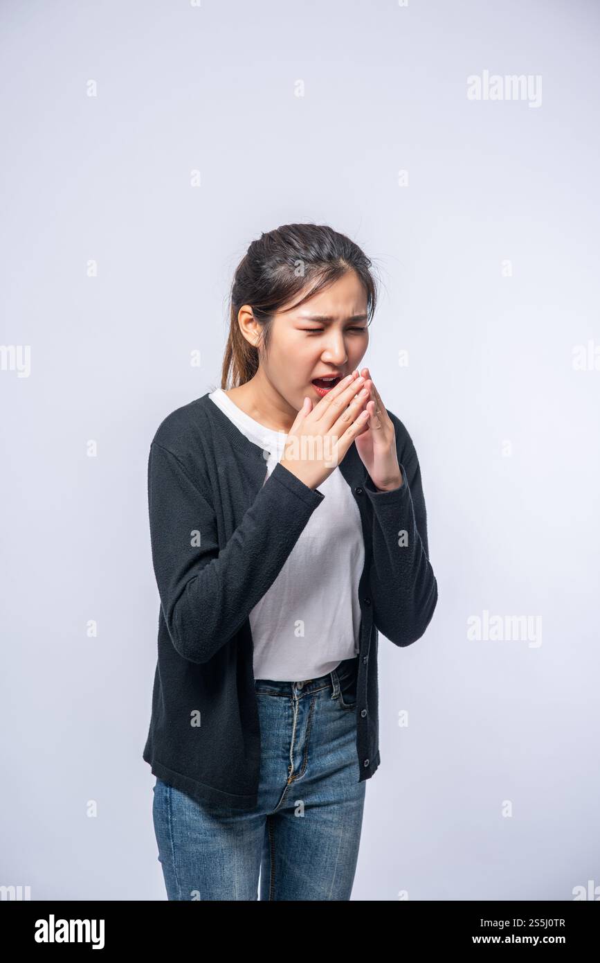 A woman coughing and covering her mouth with her hand Stock Photo - Alamy