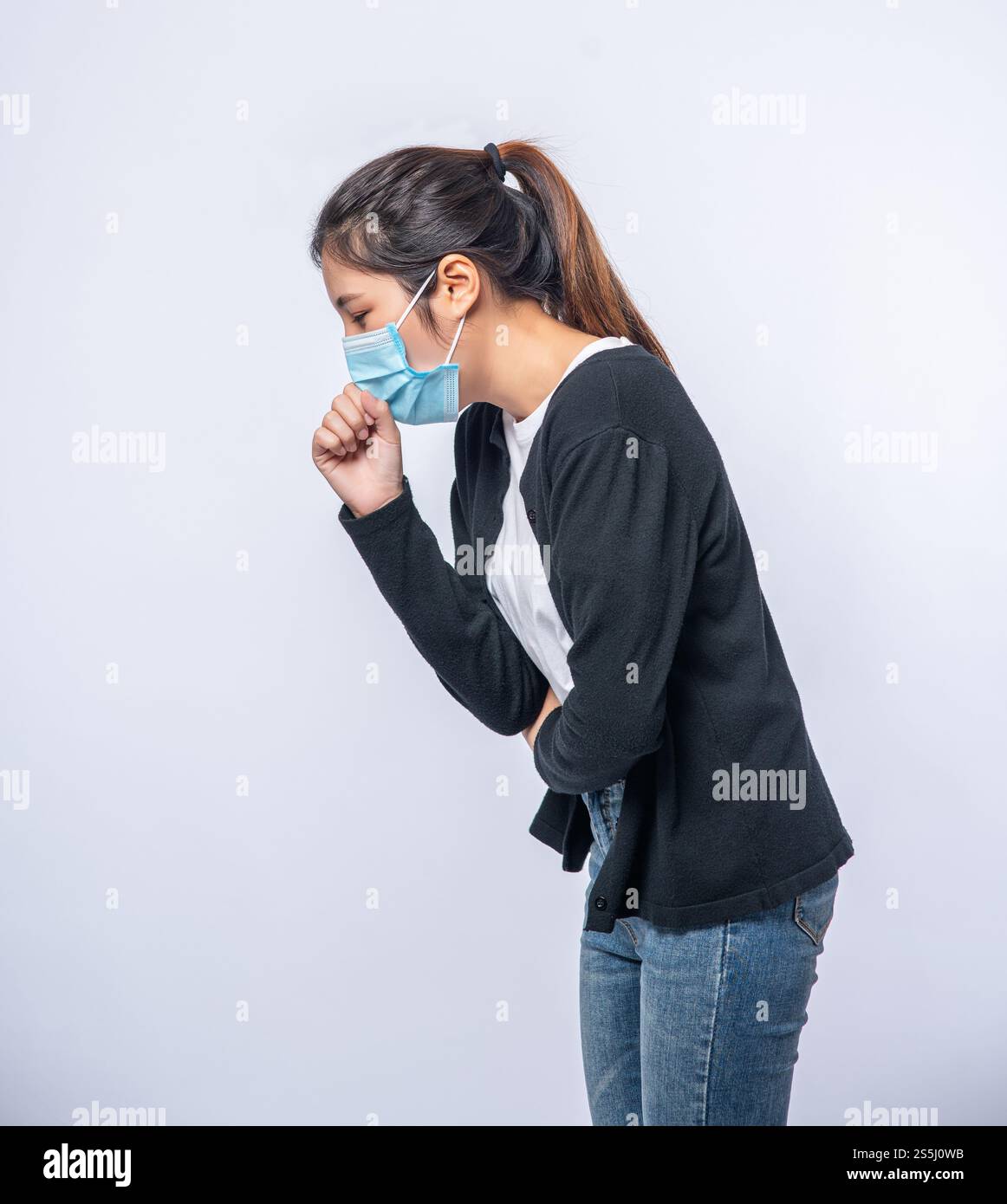 A woman coughing and covering her mouth with her hand Stock Photo - Alamy