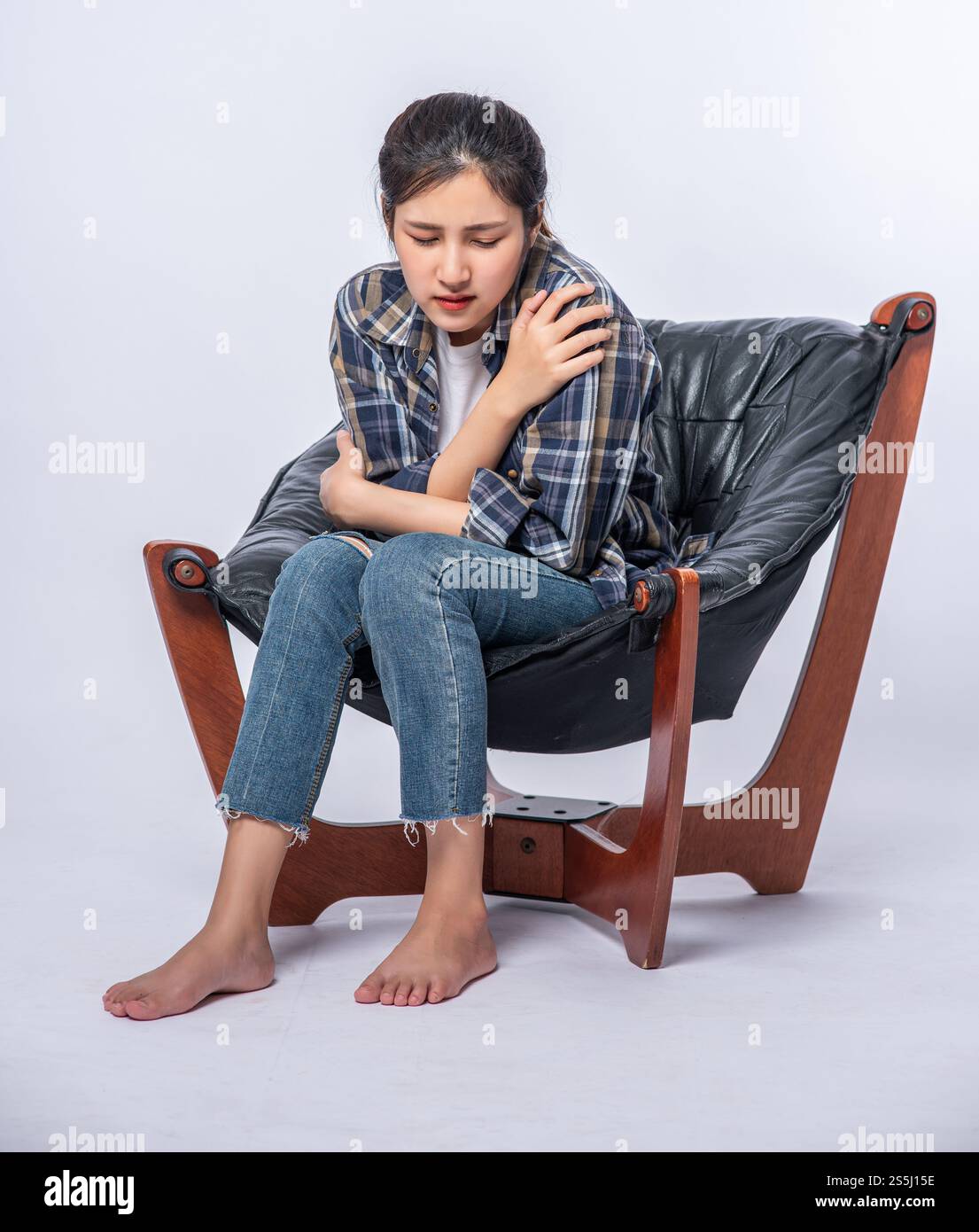 A woman who is uncomfortable and sits on a chair Stock Photo - Alamy