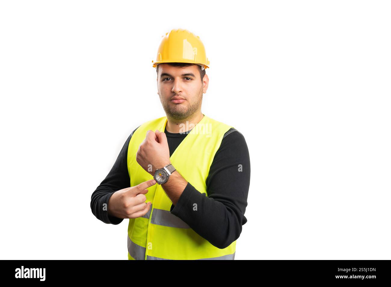 Serious male construction worker wearing safety equipment vest and hardhat pointing index finger ...