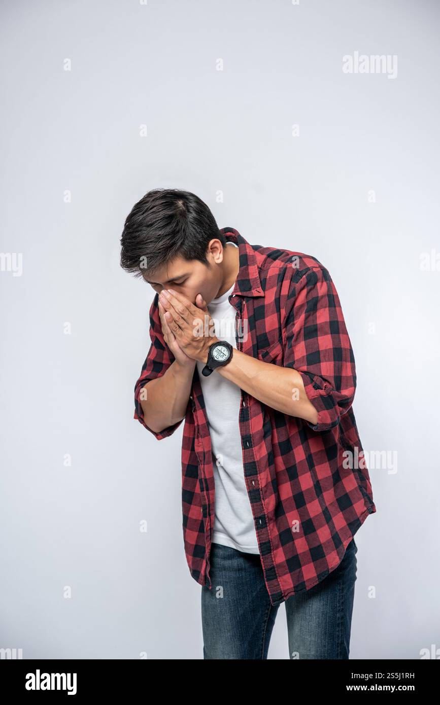 A man coughing and covering her mouth with her hand Stock Photo - Alamy