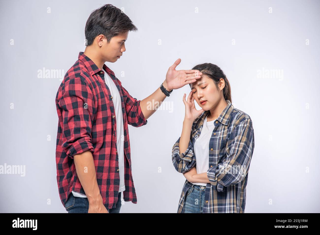 A sick woman had a man look and touch his forehead Stock Photo - Alamy