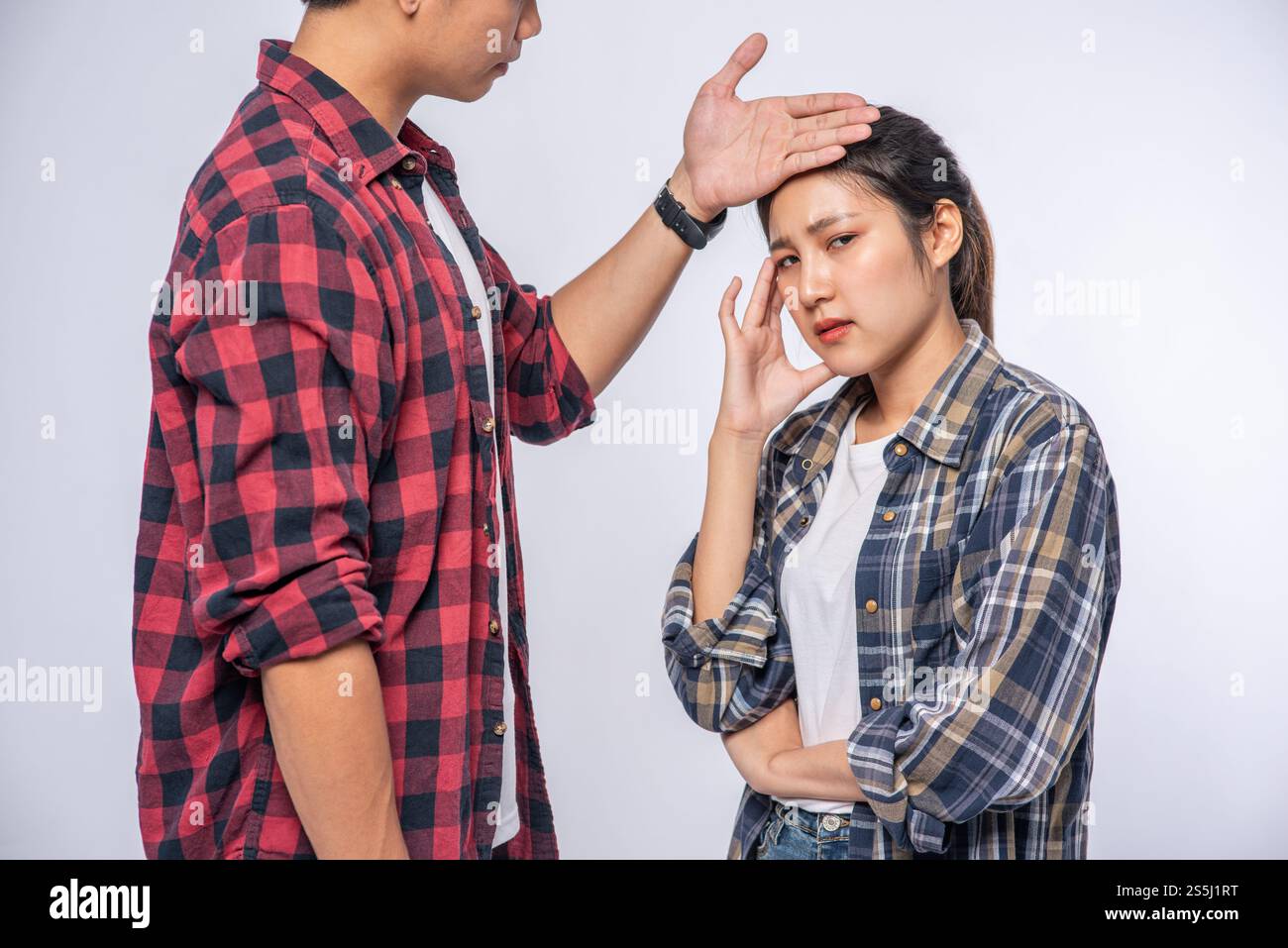 A sick woman had a man look and touch his forehead Stock Photo - Alamy