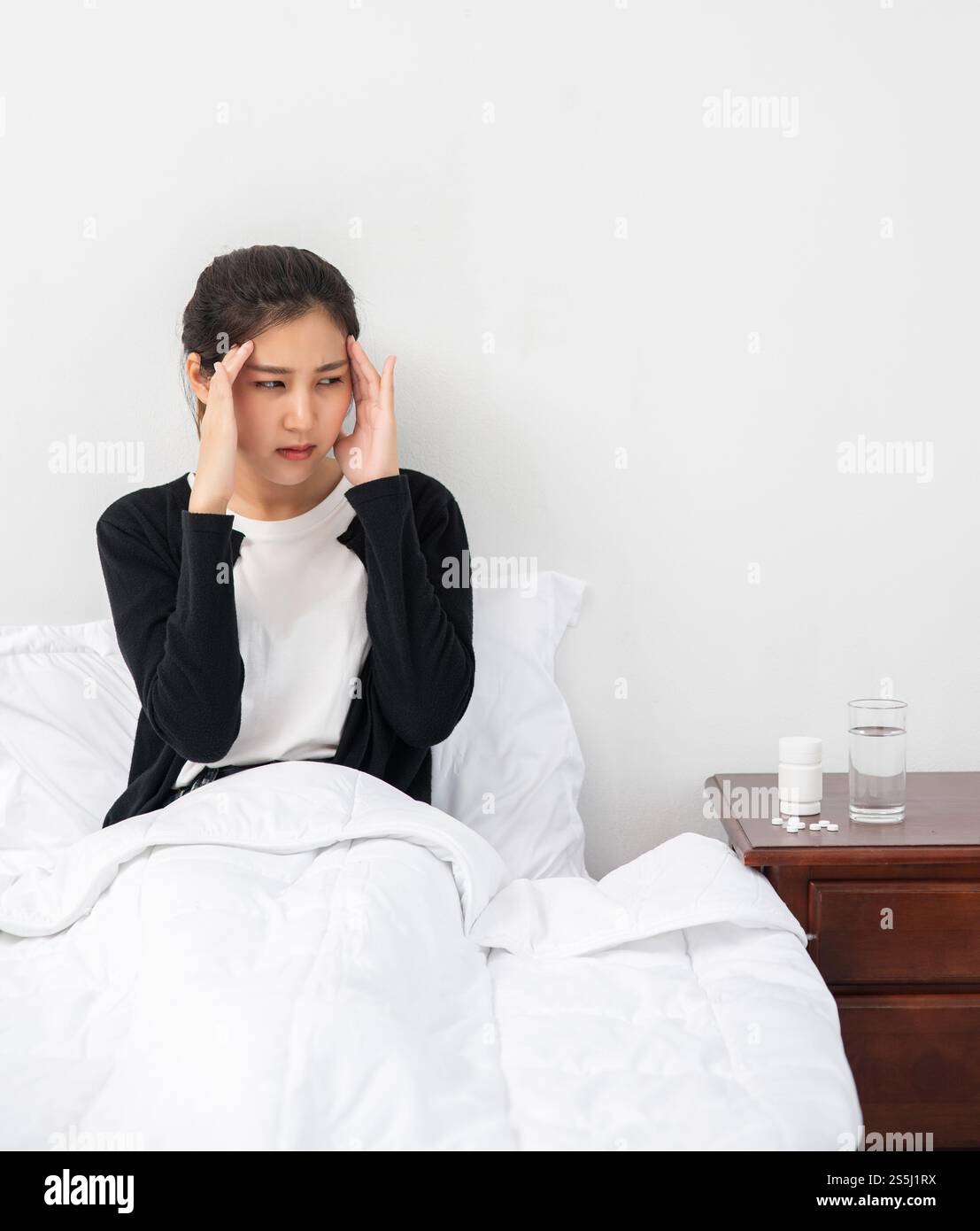 The sick woman had a headache and the hands touched her head on the bed ...