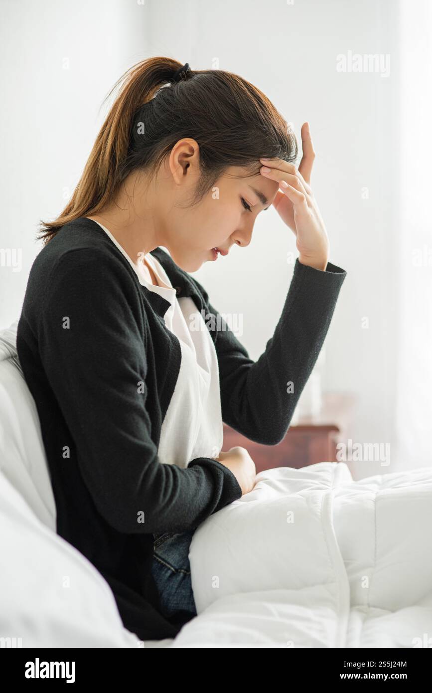 The sick woman had a headache and the hands touched her head on the bed ...
