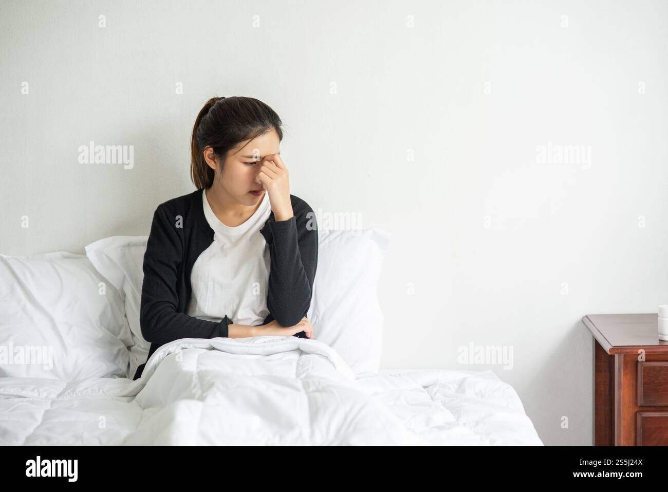 The sick woman had a headache and put her hand on her nose on the bed ...