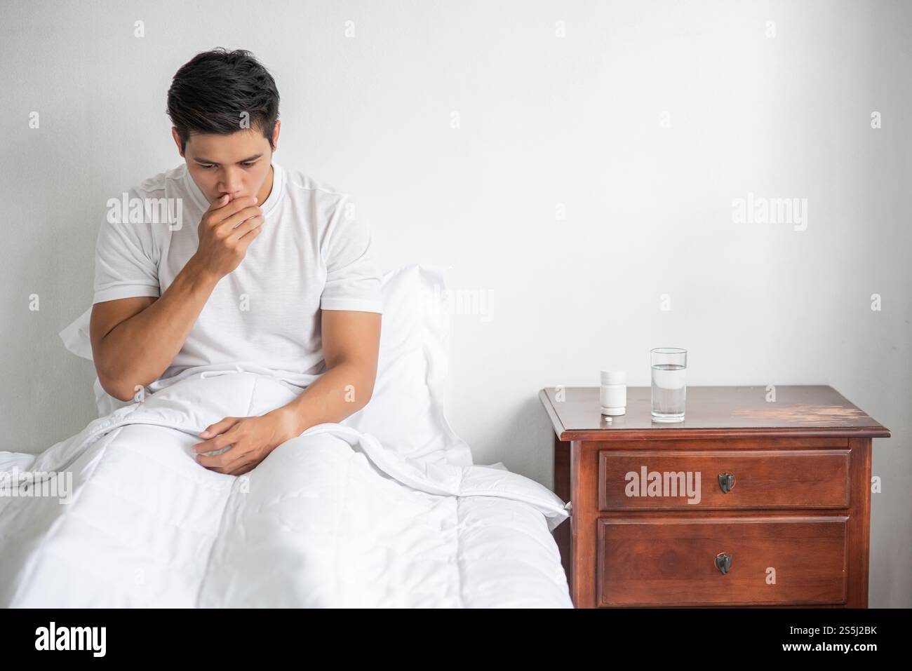 The man coughed and put his hand over his mouth and sat down on the bed ...