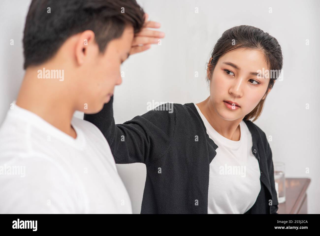 The sick man had a woman look and touch his forehead Stock Photo - Alamy
