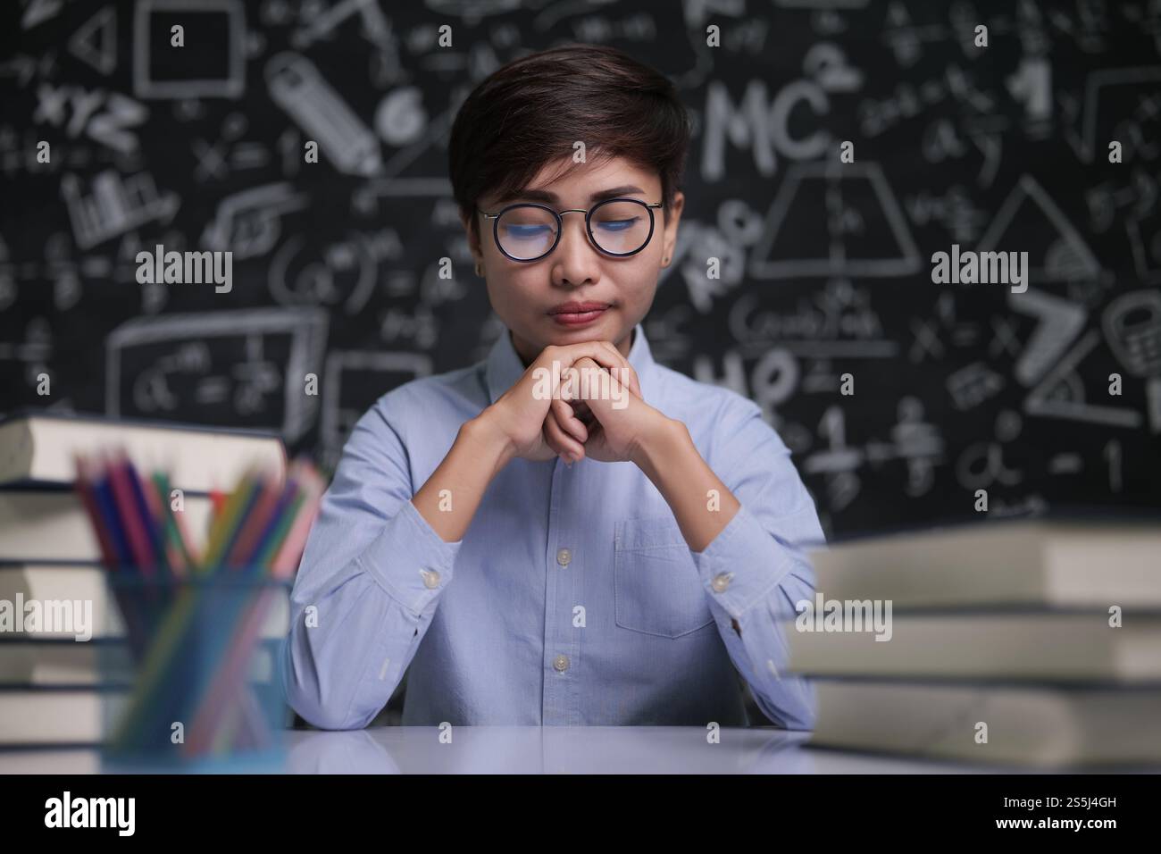 The teacher sat thinking about teaching in the classroom Stock Photo - Alamy