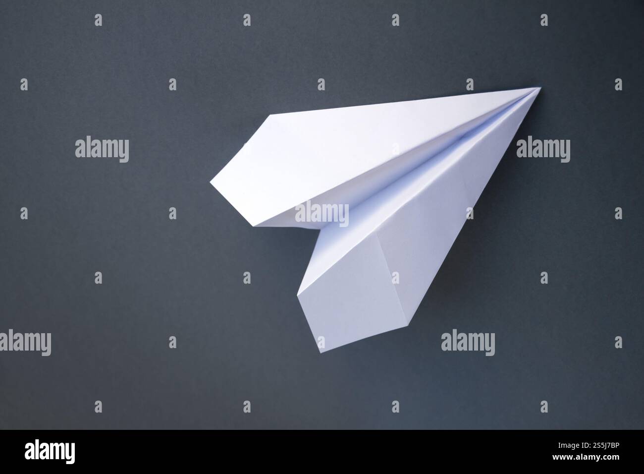 White paper plane origami isolated on a blank grey background. White ...