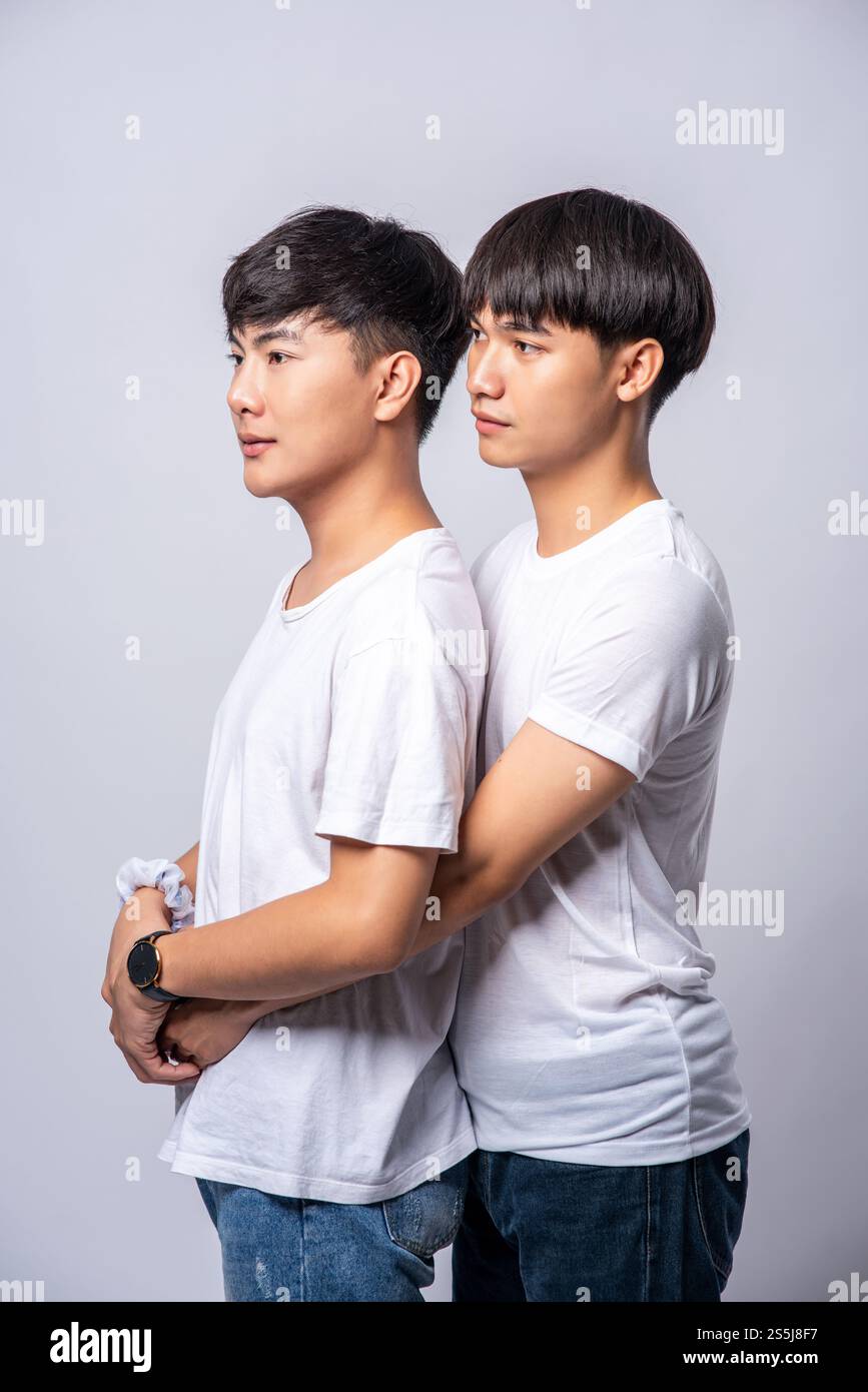 Two men who love each other hug from behind another Stock Photo - Alamy