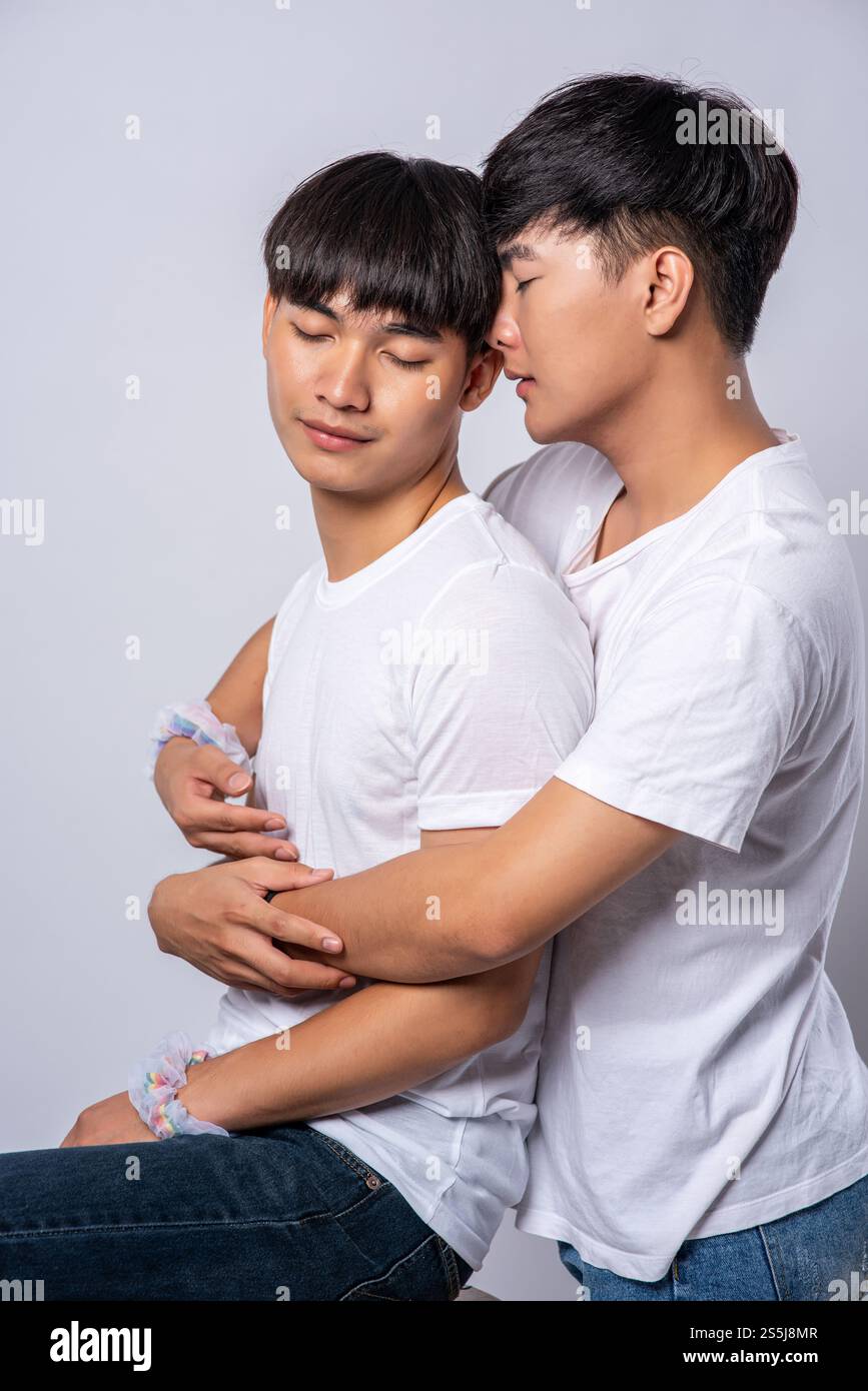 Two men who love each other hug from behind another Stock Photo - Alamy