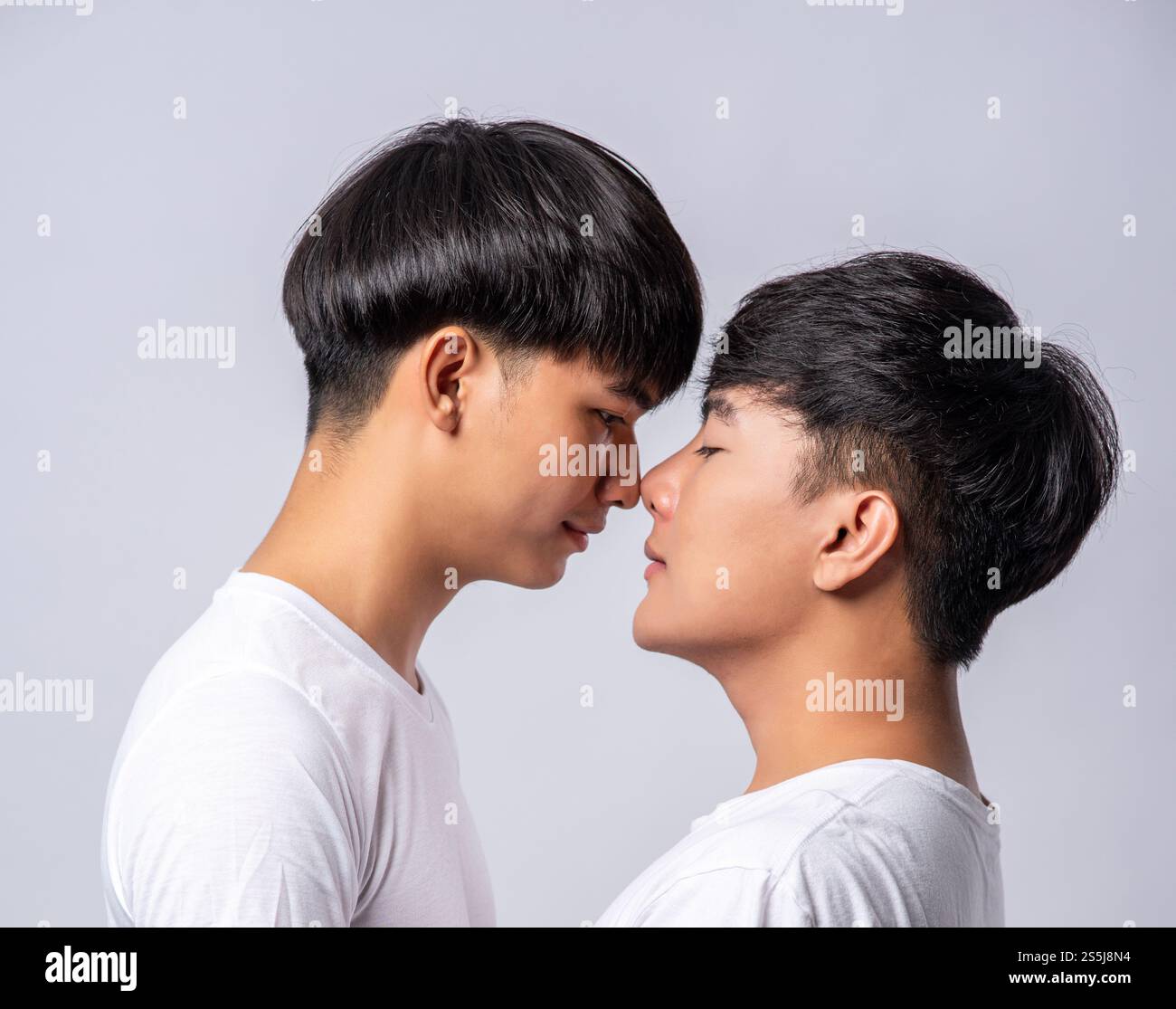 Two men in love wearing white t-shirts looked at each others faces ...