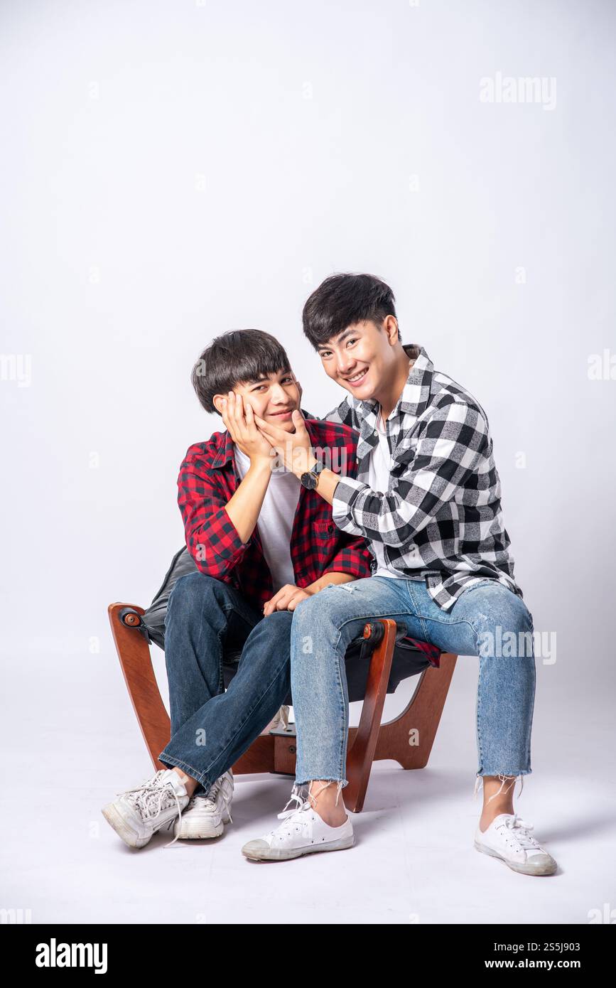 Two men who love each other hug and sit on a chair Stock Photo - Alamy