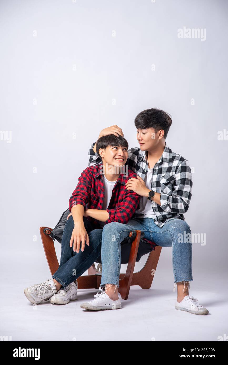 Two men who love each other hug and sit on a chair Stock Photo - Alamy