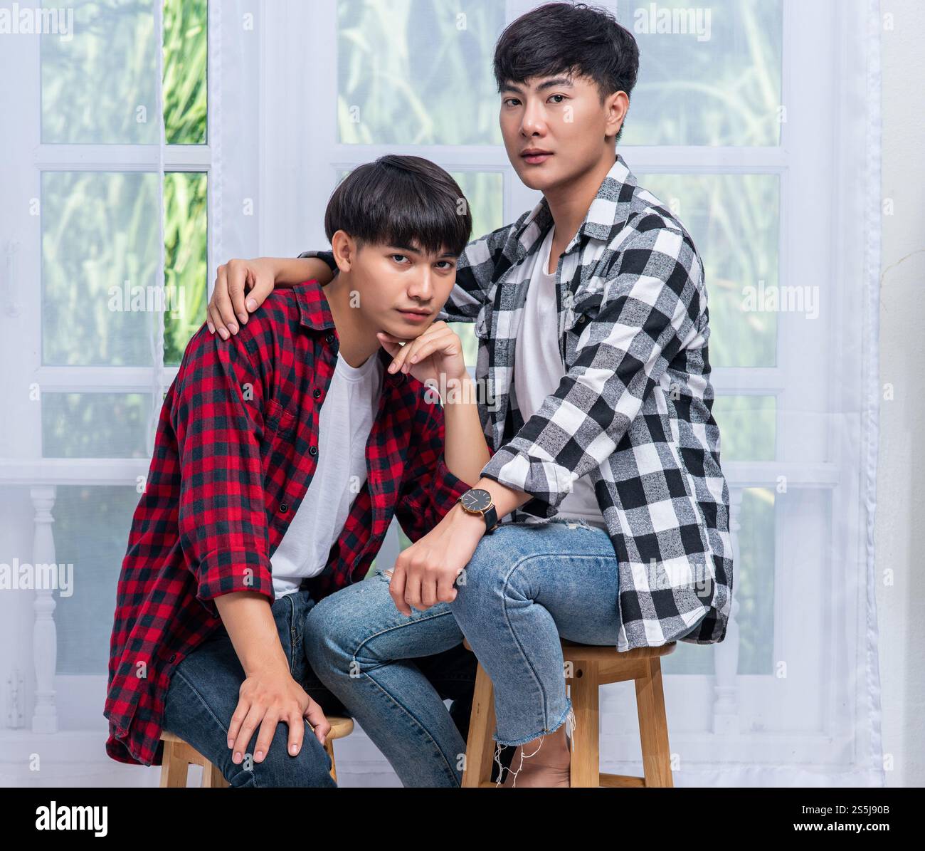 Two men who love each other hug and sit on a chair Stock Photo - Alamy