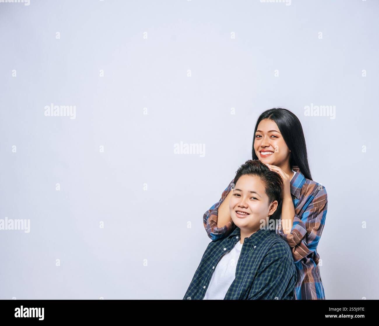 Two women in love stand and place their hands on each others heads ...