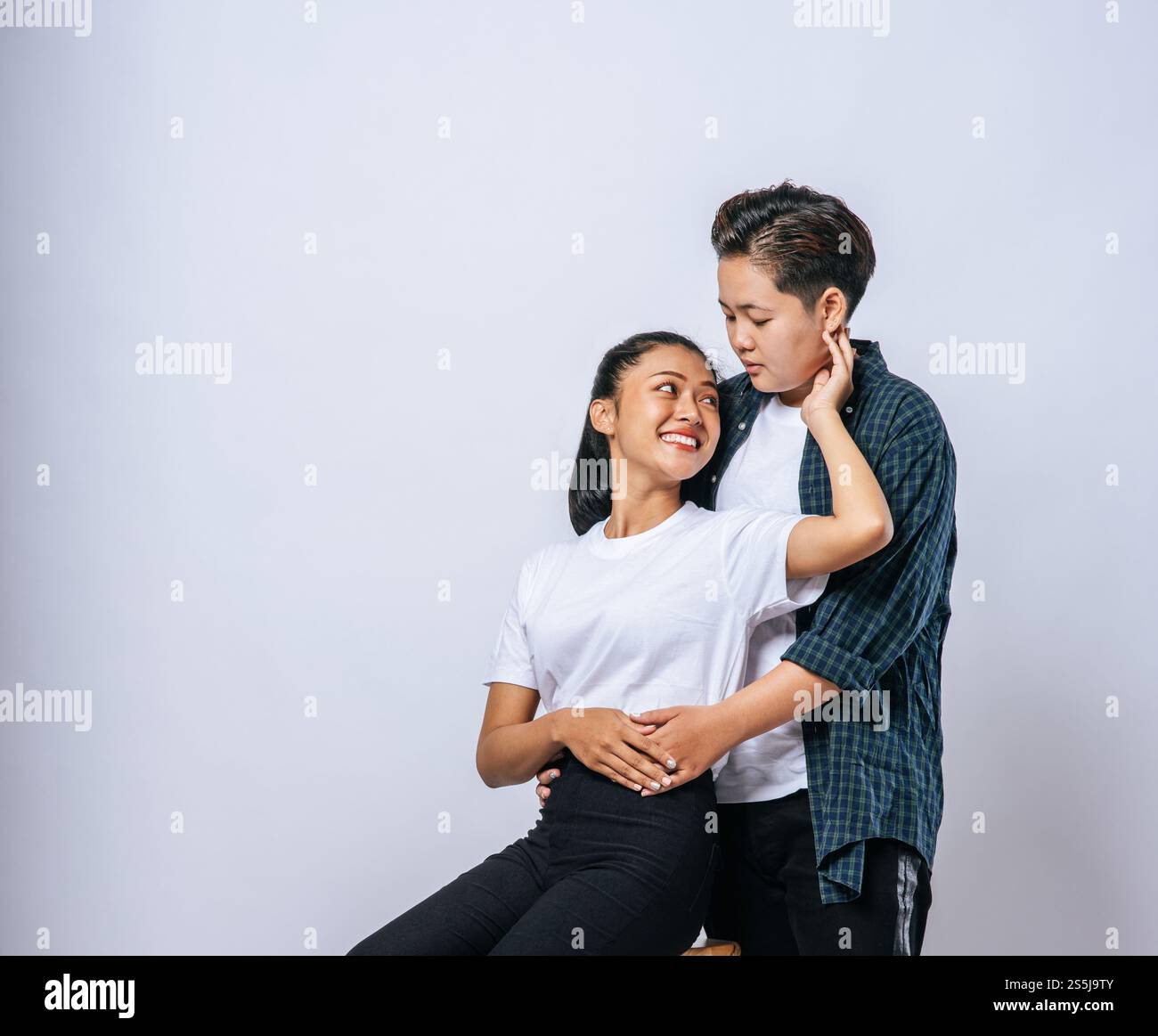 Two female lovers standing and hugging from behind Stock Photo - Alamy