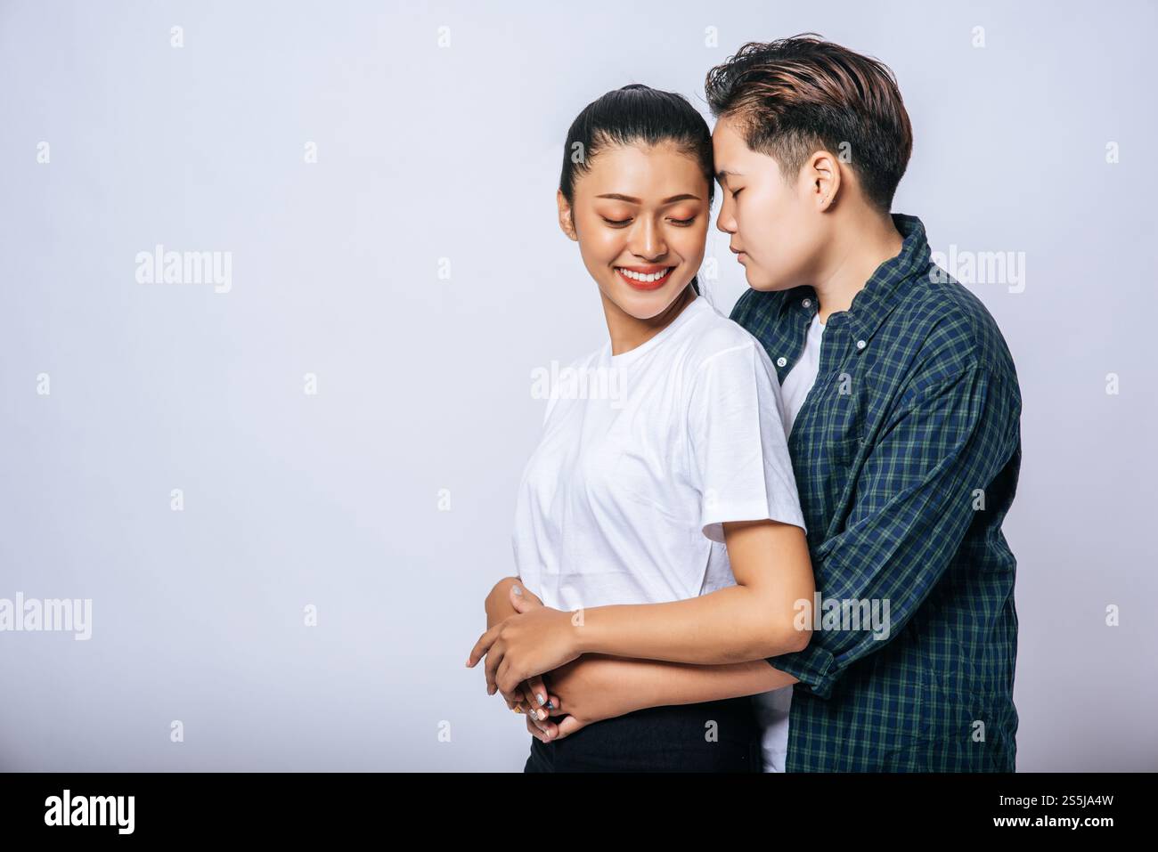 Two female lovers standing and hugging from behind Stock Photo - Alamy