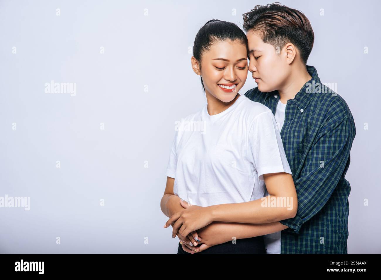 Two female lovers standing and hugging from behind Stock Photo - Alamy