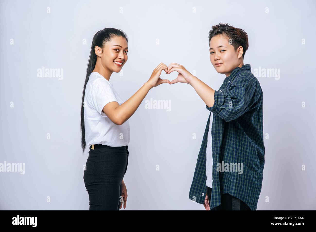 Two young women love each other hand mark heart shape Stock Photo - Alamy