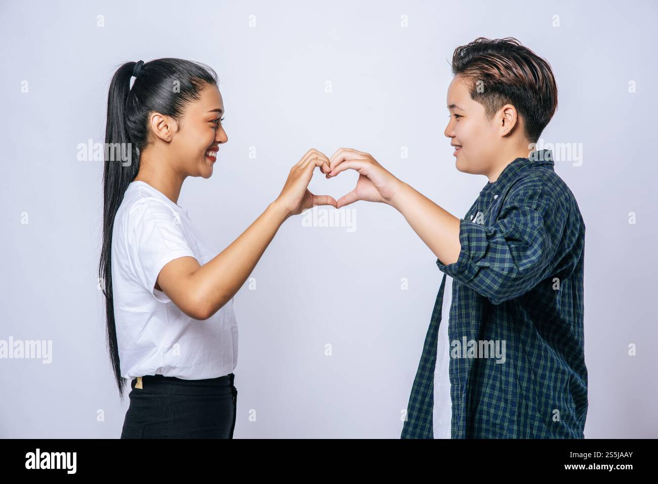 Two young women love each other hand mark heart shape Stock Photo - Alamy