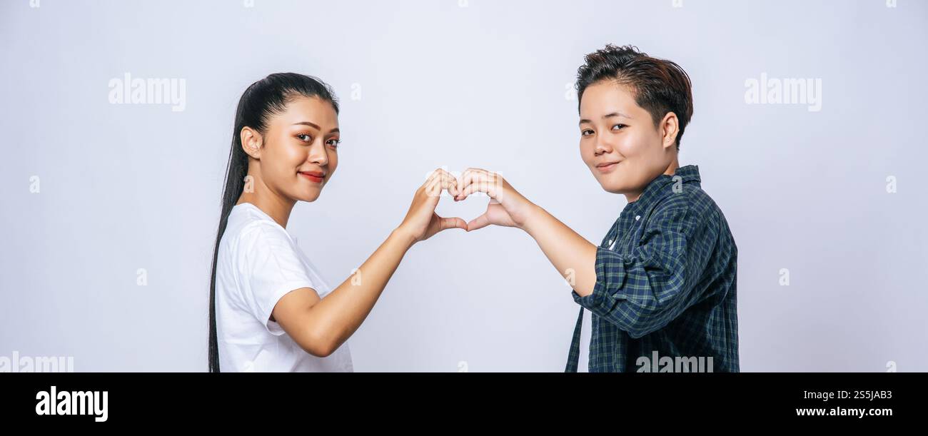 Two young women love each other hand mark heart shape Stock Photo - Alamy