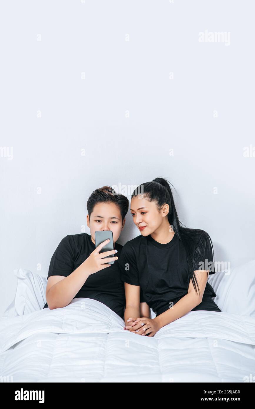 Two loving women sleeping and playing smartphones Stock Photo - Alamy