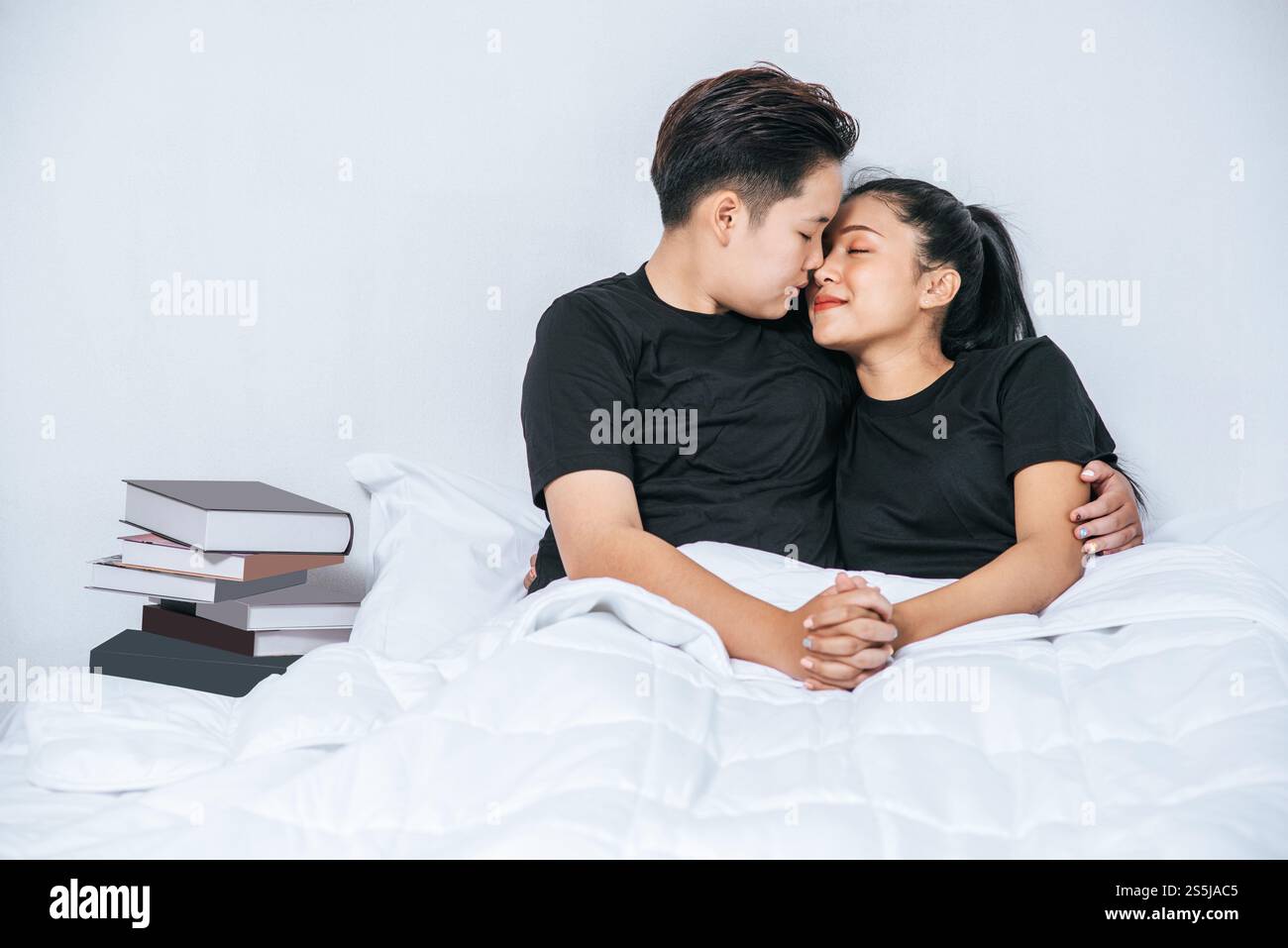 Two female couples cuddled together in bed Stock Photo - Alamy