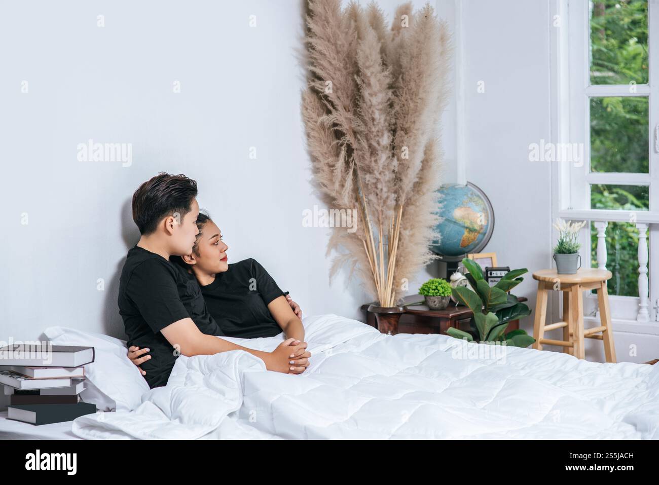 Two female couples cuddled together in bed Stock Photo - Alamy