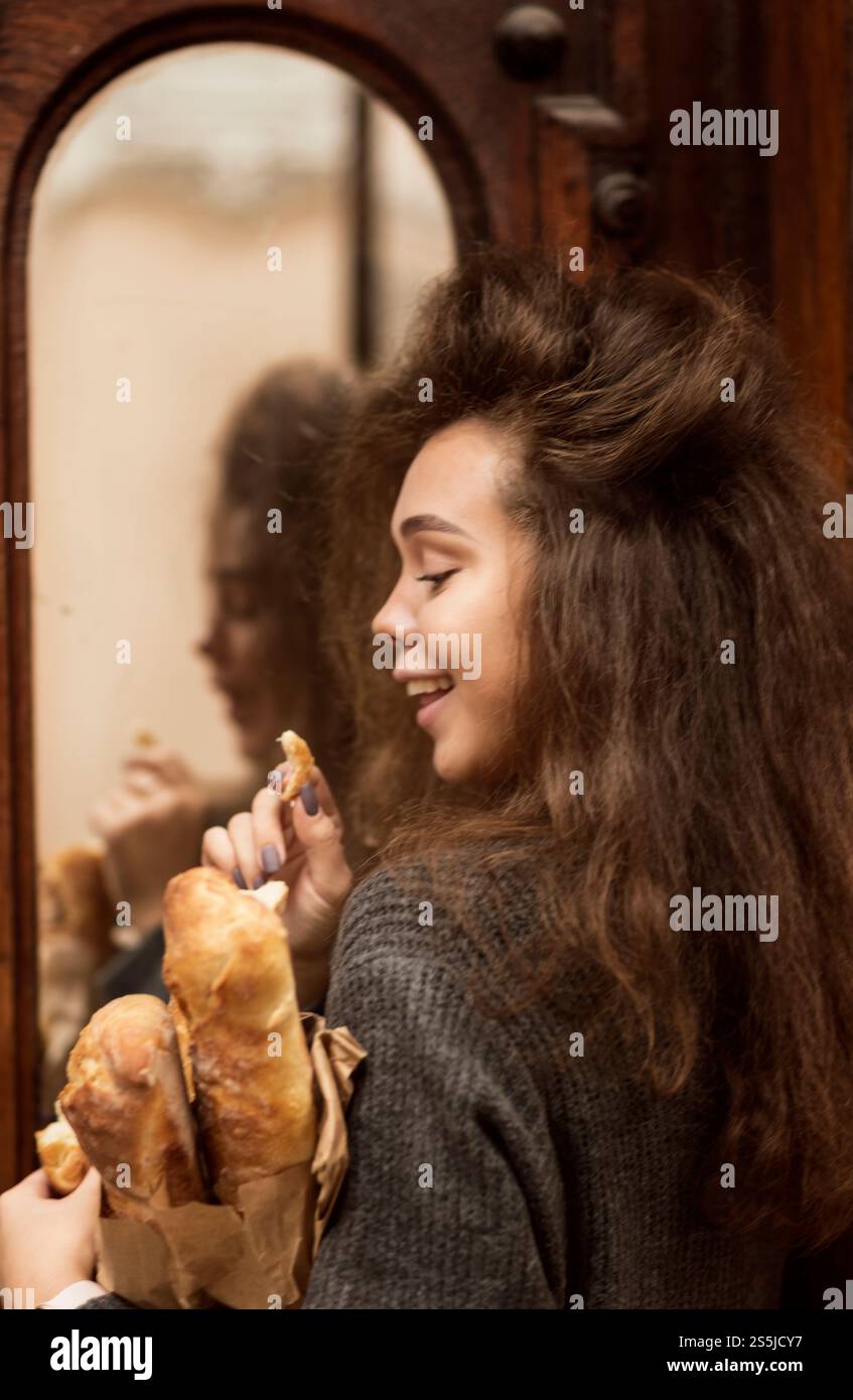 A person sitting at a table eating a donut Stock Photo - Alamy
