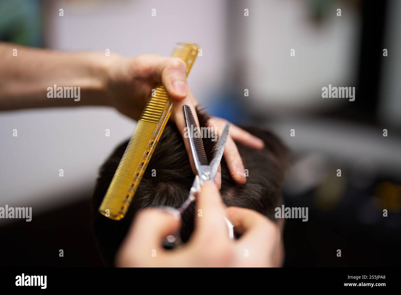 Haircut in progress at a barbershop with professional tools involved ...
