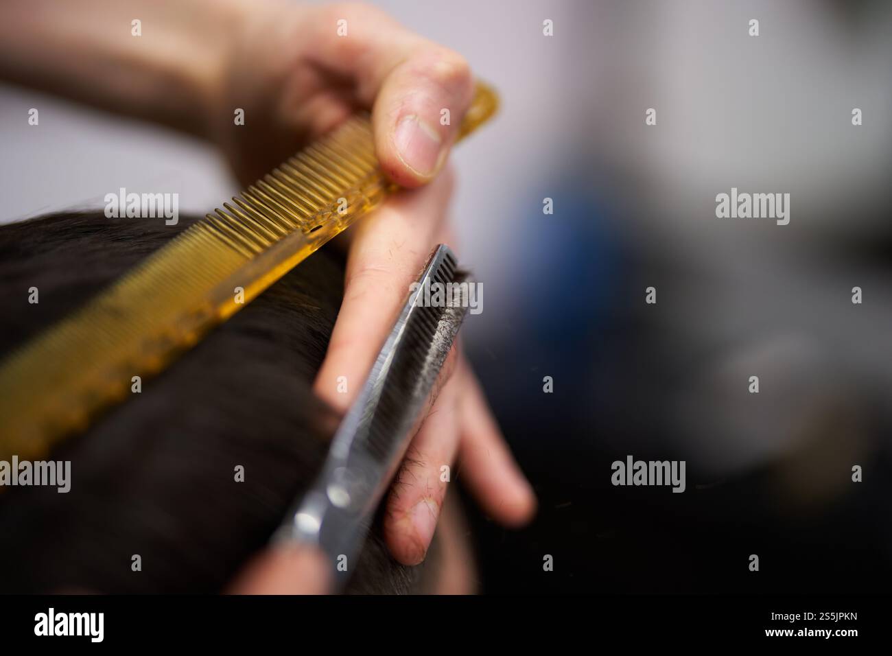 Haircut taking place at a barbershop with tools in use for styling ...