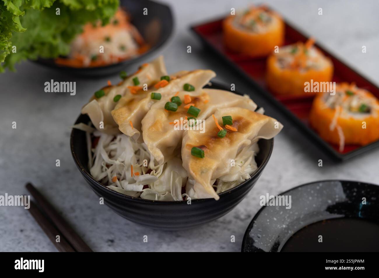 Gyoza in a black cup with a cup of sauce Stock Photo - Alamy