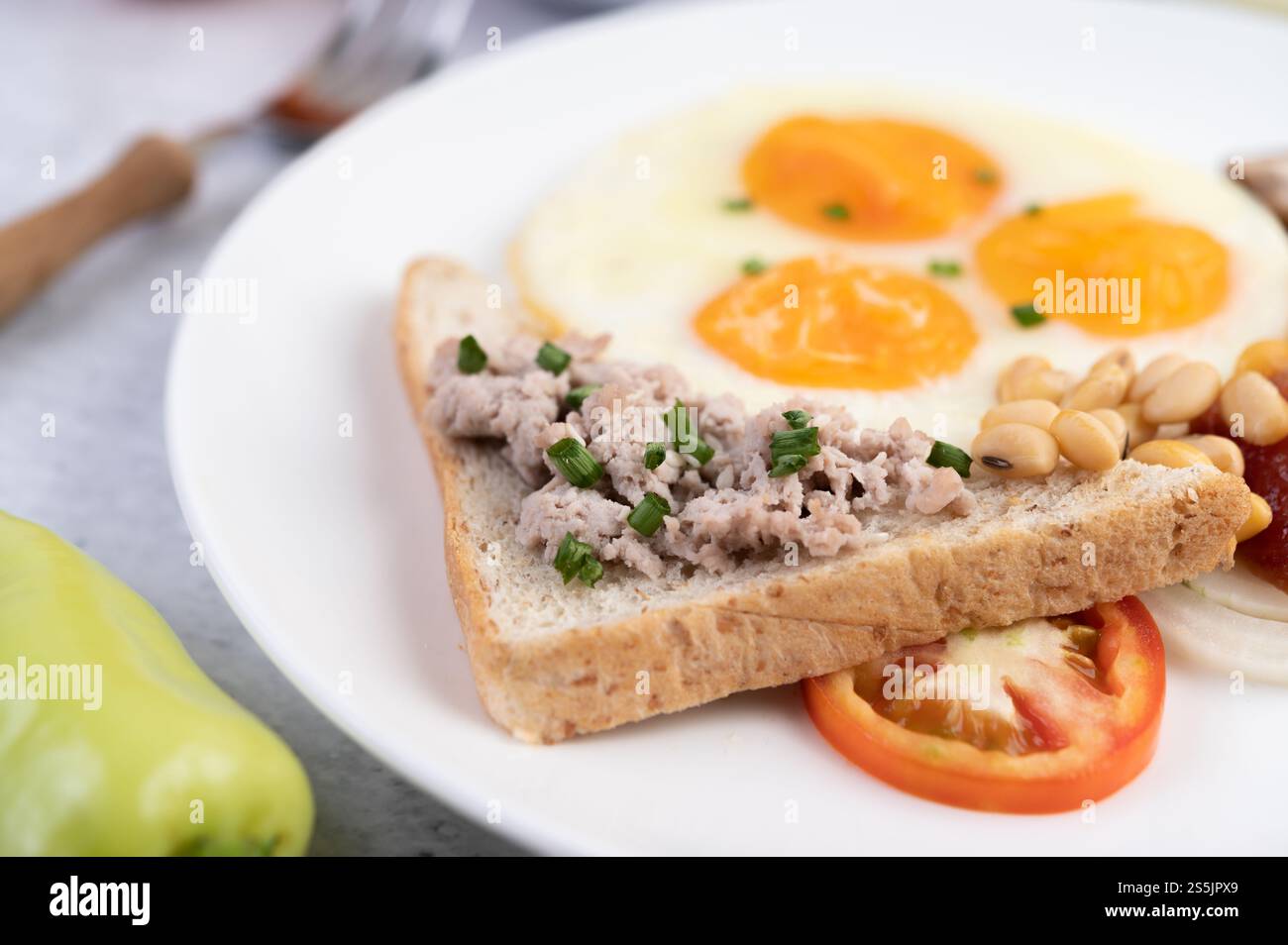 Breakfast consists of fried eggs, sausage, minced pork, bread, red ...