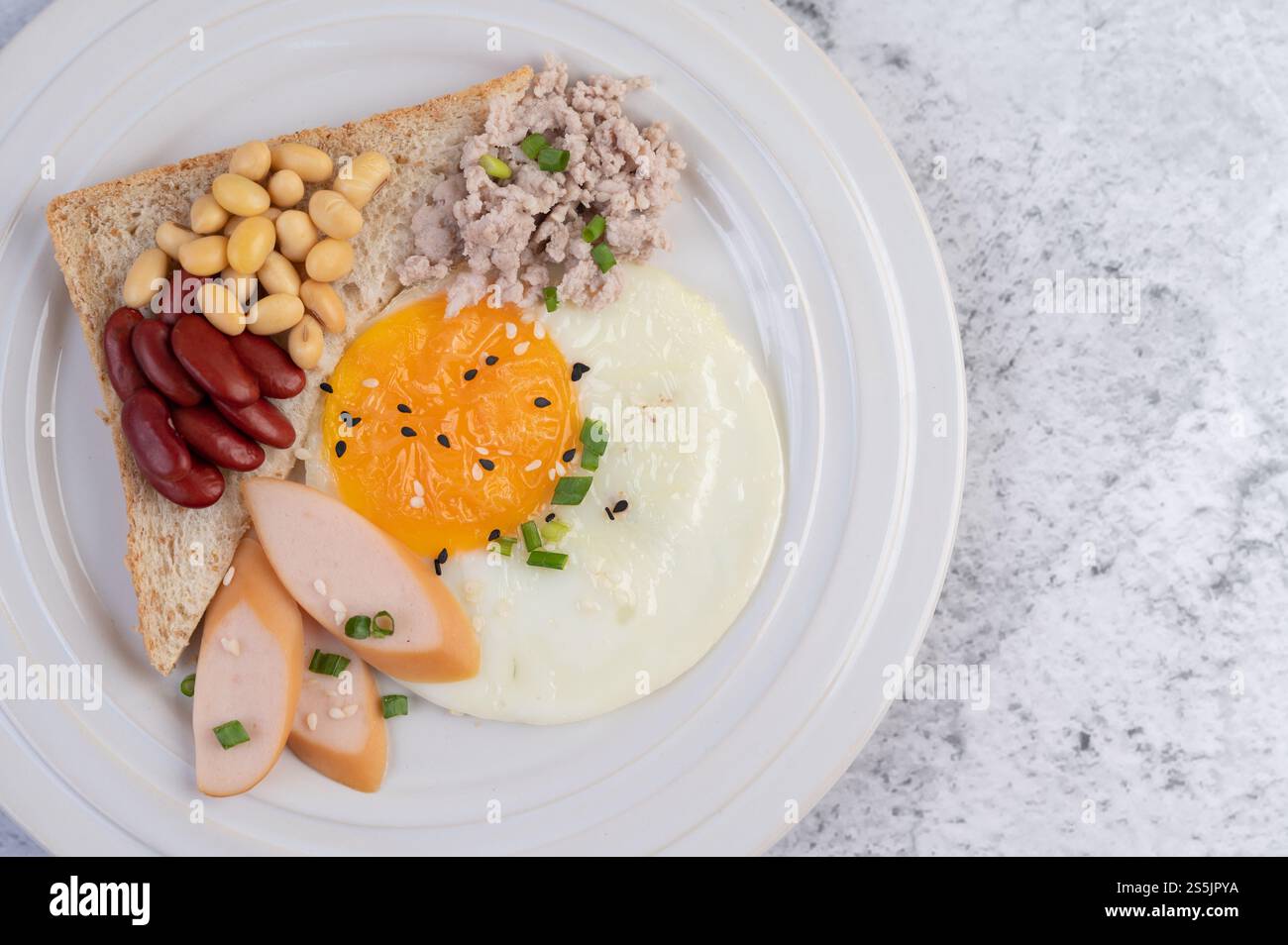 Breakfast consists of fried eggs, sausage, minced pork, bread, red ...