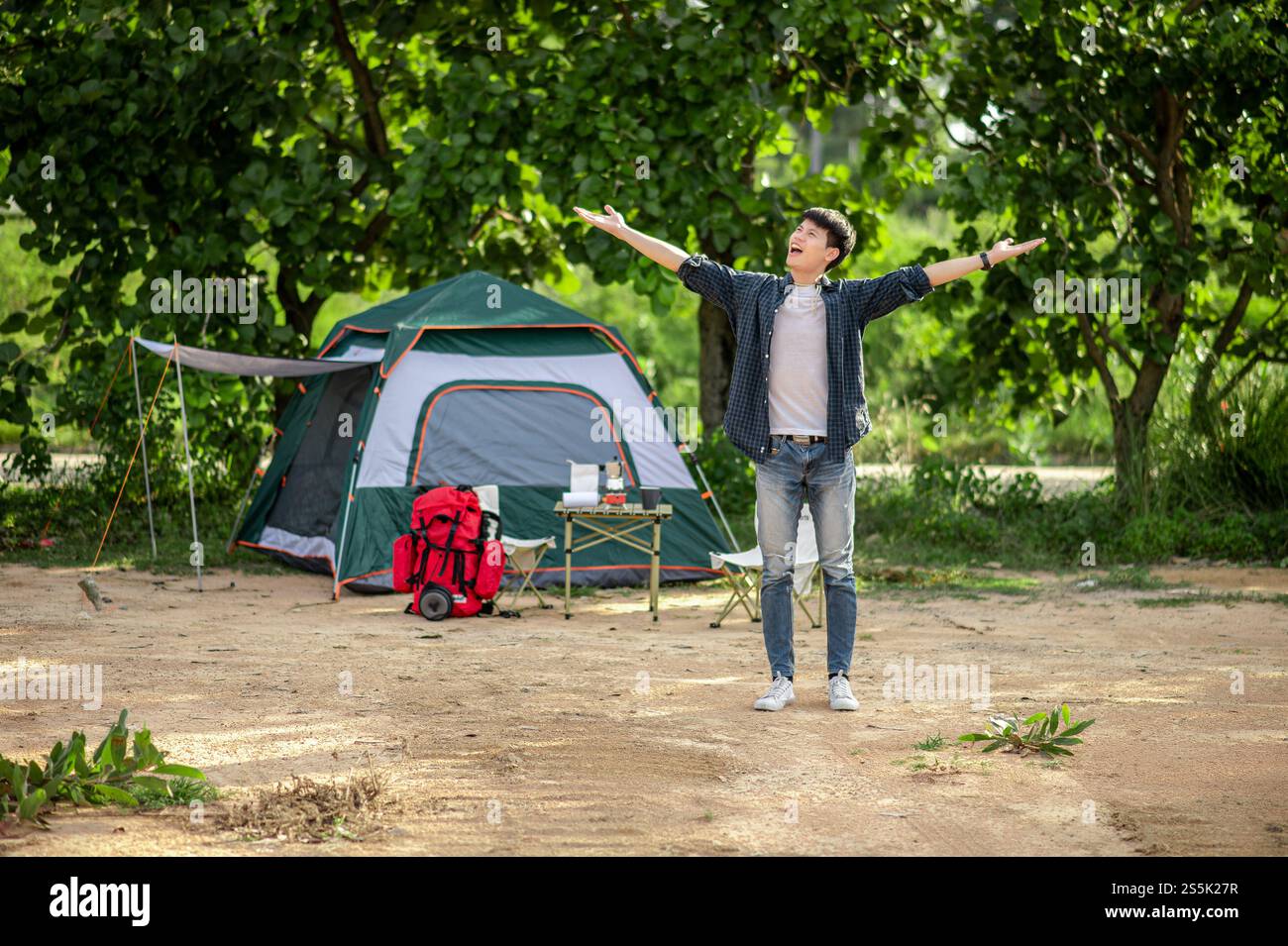 Cheerful Young backpacker man standing and open arms at front of the ...