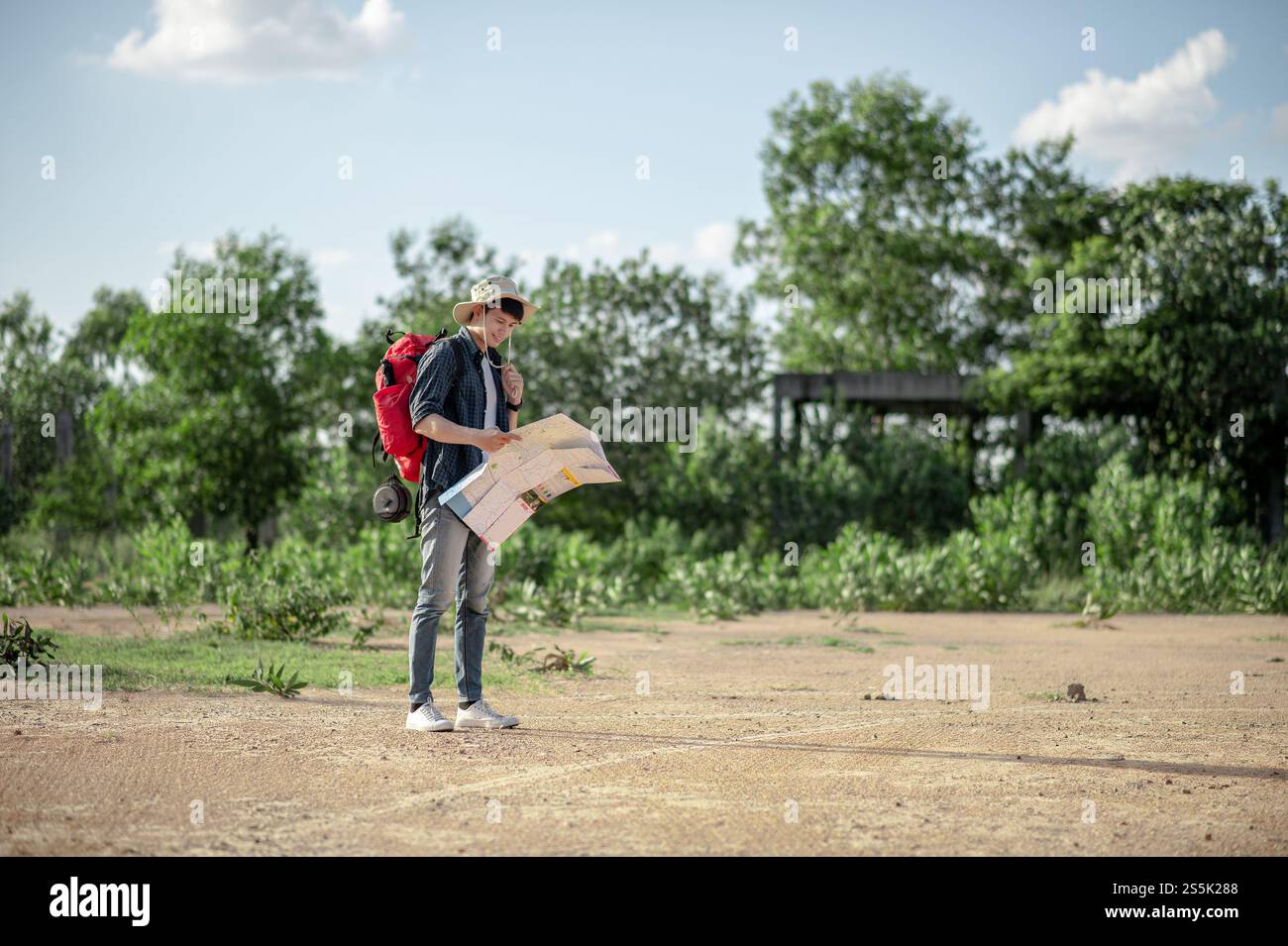 Young backpacker man wearing hat with map for checking direction, He ...