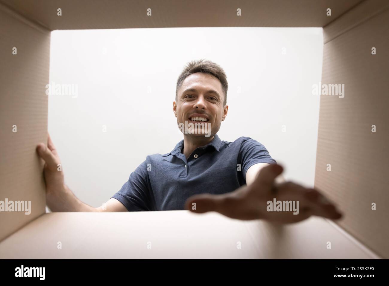 Young man getting long awaited parcel, cardboard box bottom view Stock ...