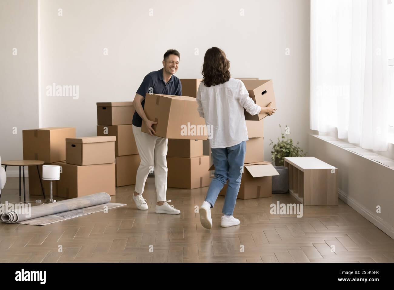 Millennial couple carrying big cardboard boxes on relocation day Stock ...