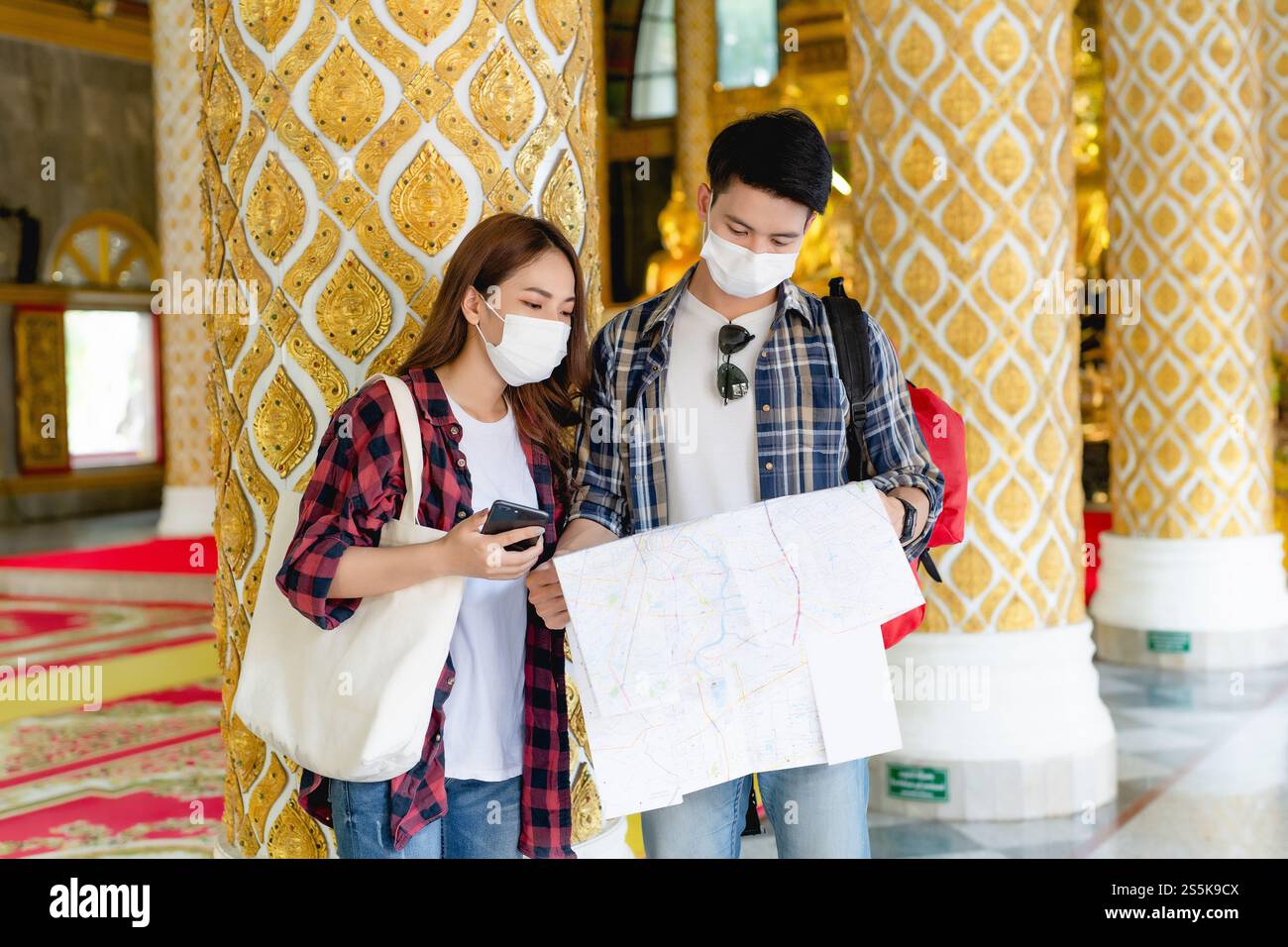 Asian couple tourist backpackers in mask standing in beautiful Thai ...