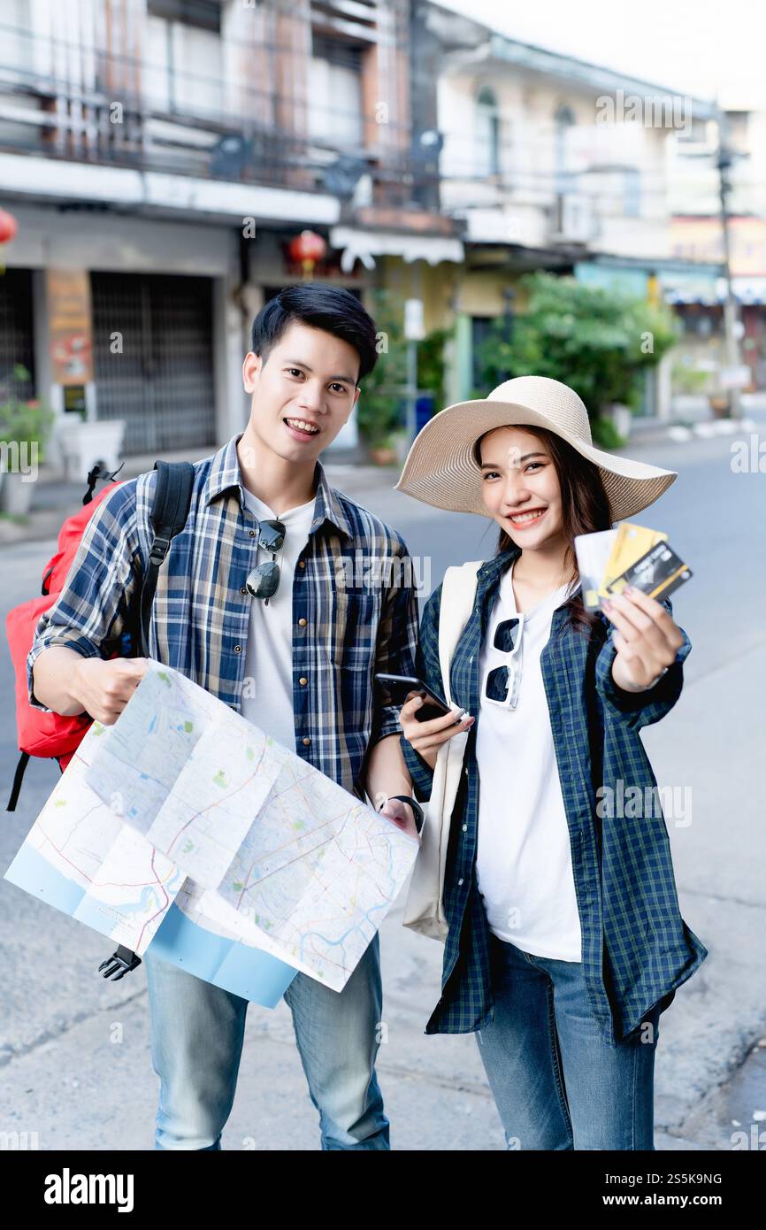 Young backpacker man holding paper map and pretty woman wear sombrero ...