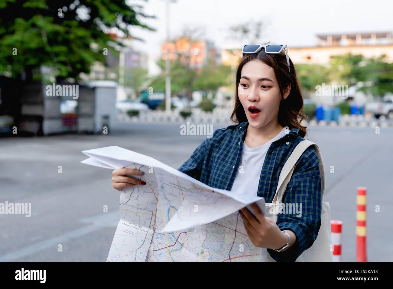 Young tourist female holding and checking on paper map, She looking ...