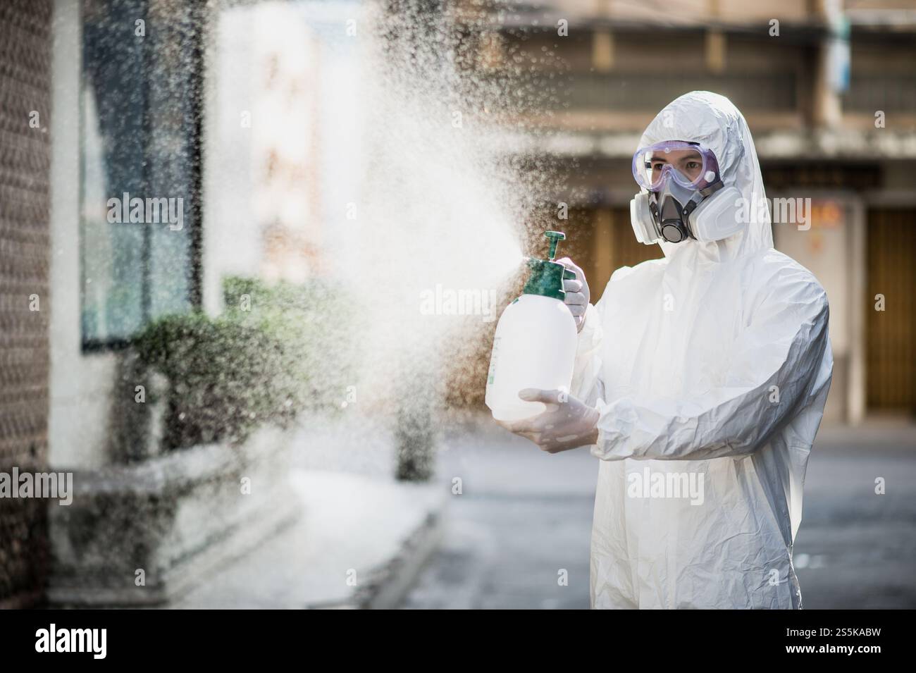 Disinfection specialist man in personal protective equipment (ppe) suit ...