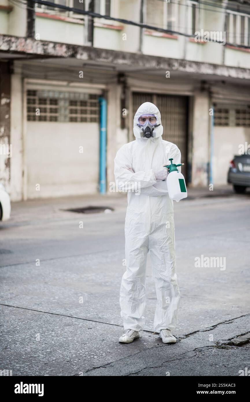 Disinfection specialist man in personal protective equipment (ppe) suit ...
