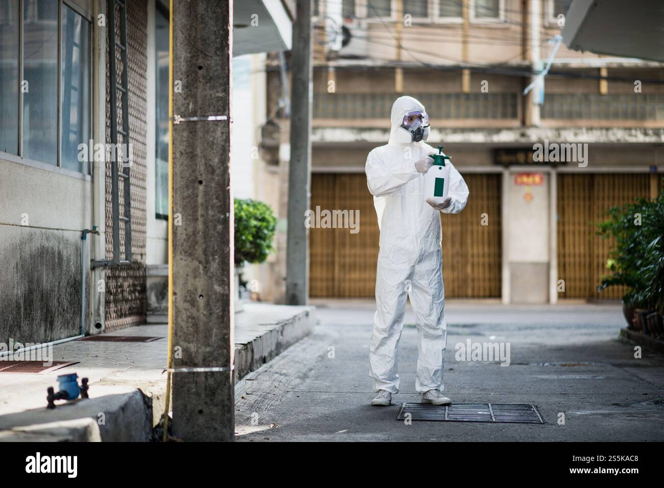 Disinfection specialist man in personal protective equipment (ppe) suit ...