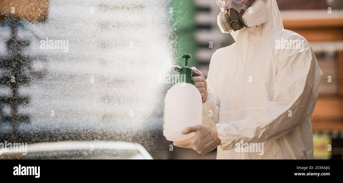 Disinfection specialist man in personal protective equipment (ppe) suit ...