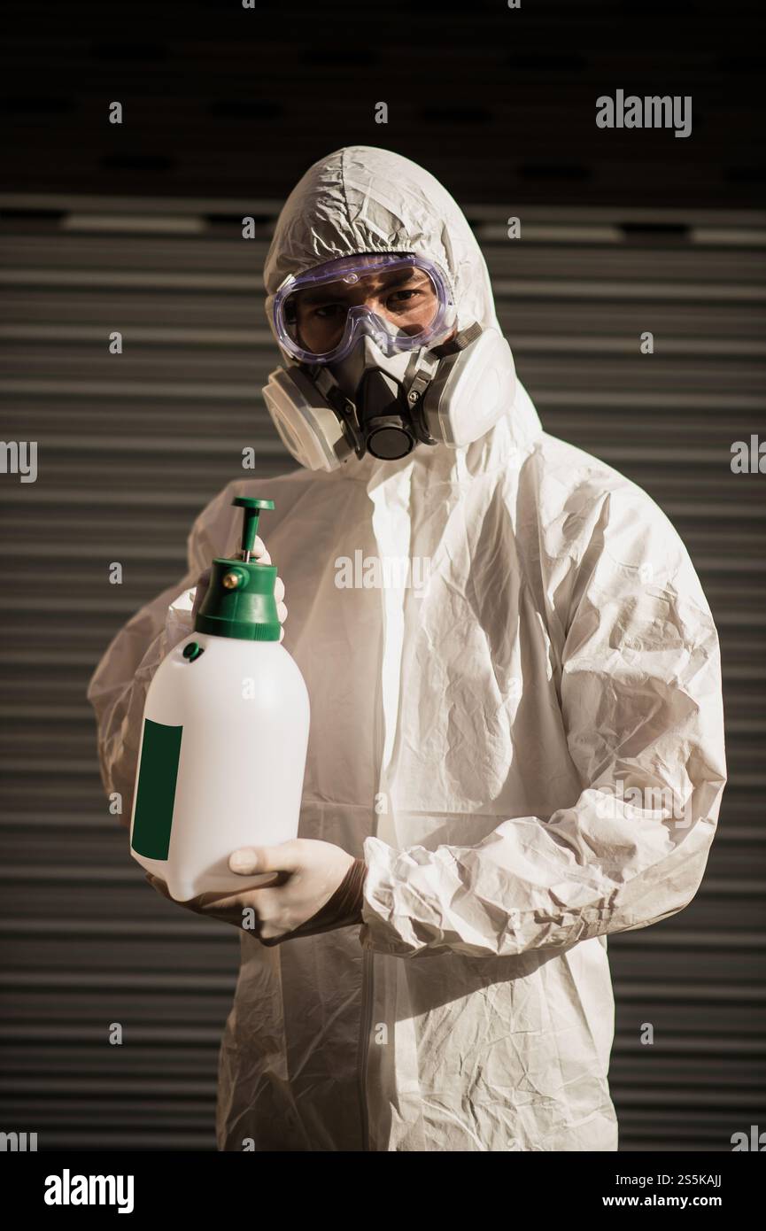 Disinfection specialist man in personal protective equipment (ppe) suit ...